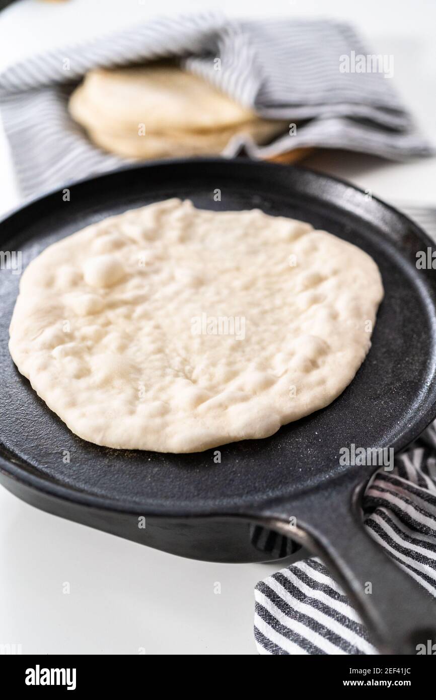 Preparing homemade flatbread on a cast-iron skillet Stock Photo - Alamy