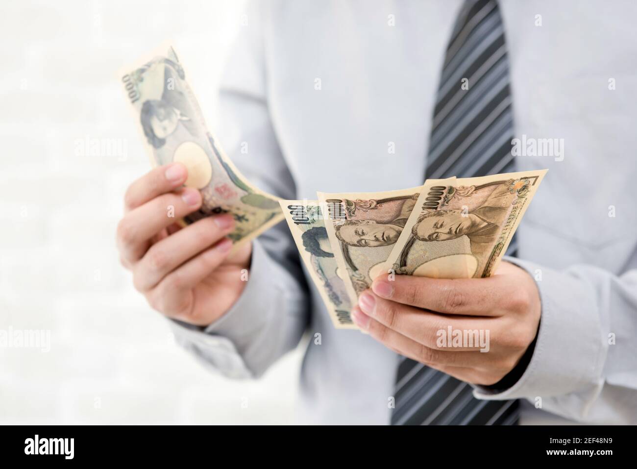 Businessman counting money, Japanese yen banknotes Stock Photo - Alamy