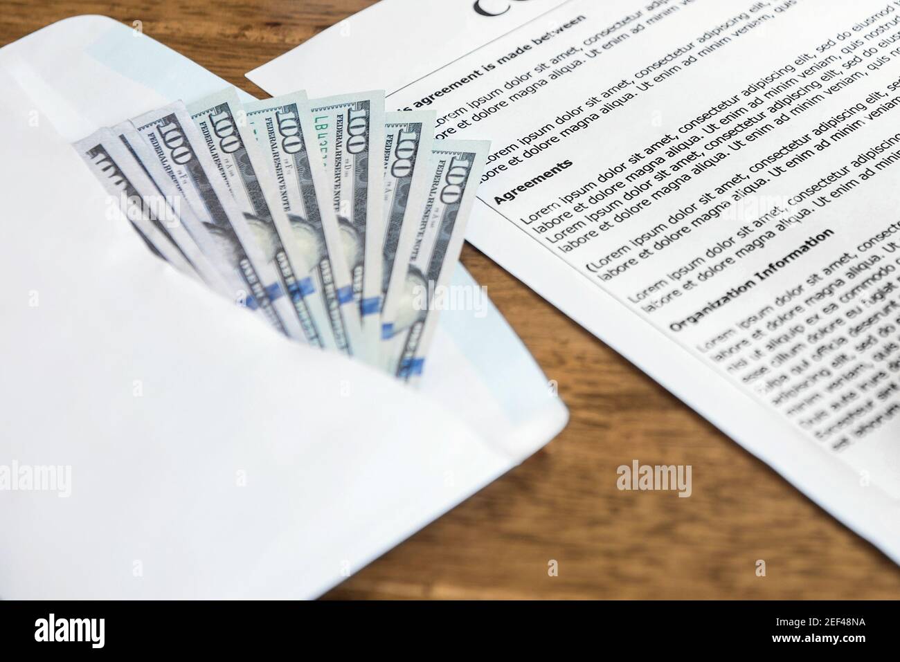 Money (US dollar bills) on the table beside contract paper - loan ...
