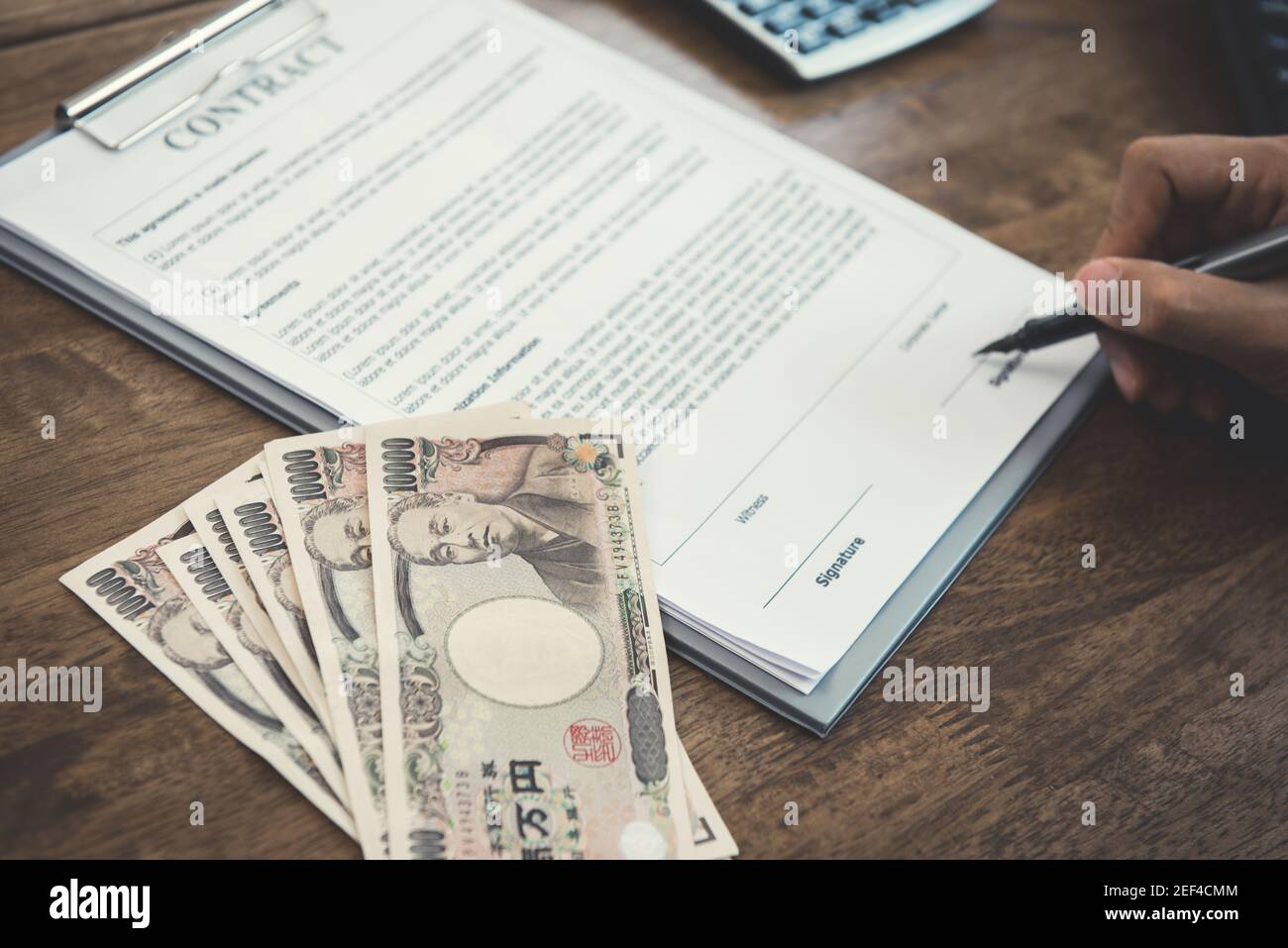 Businessman signing contract with money, Japanese yen banknotes, on the ...