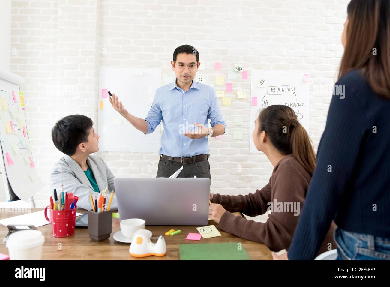 Teacher and college students discussing project in classroom Stock ...