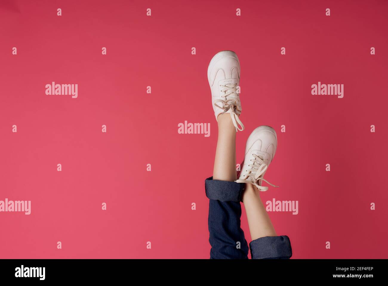 Inverted female legs white sneakers motion street style pink background ...