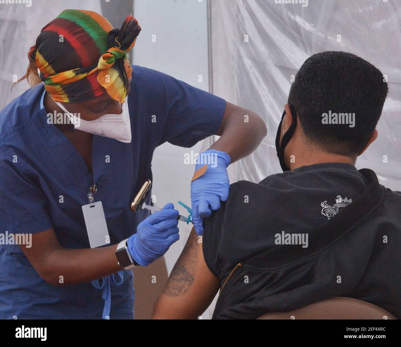 A local resident receives a COVID-19 vaccination shot at the Kedren ...