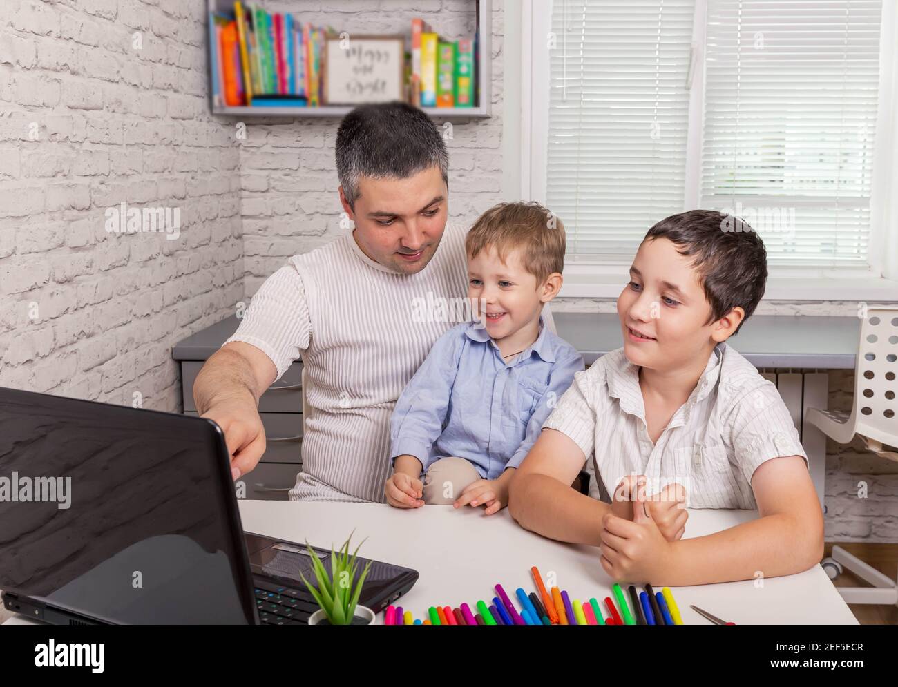 Dad with sons using laptop together looking at screen. Conference Stock ...