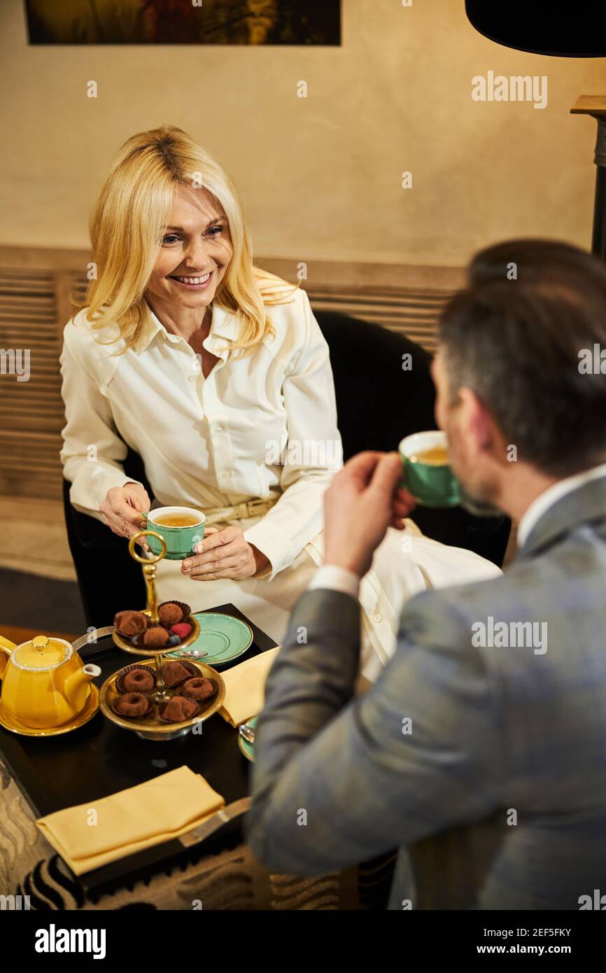 Charming woman having tea with an elegant gentleman Stock Photo - Alamy