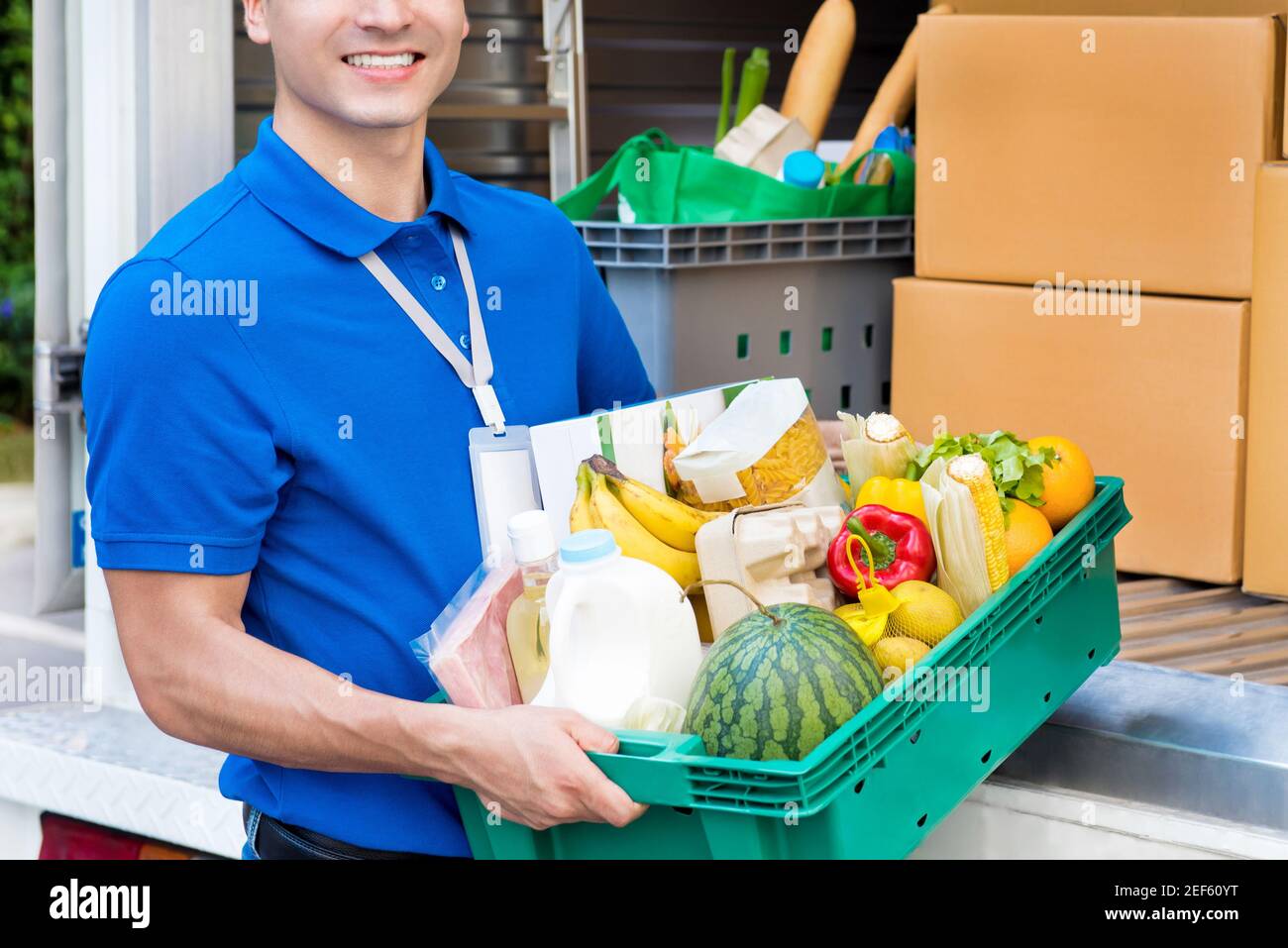 Delivery man taking food basket from the car delivering to customer ...