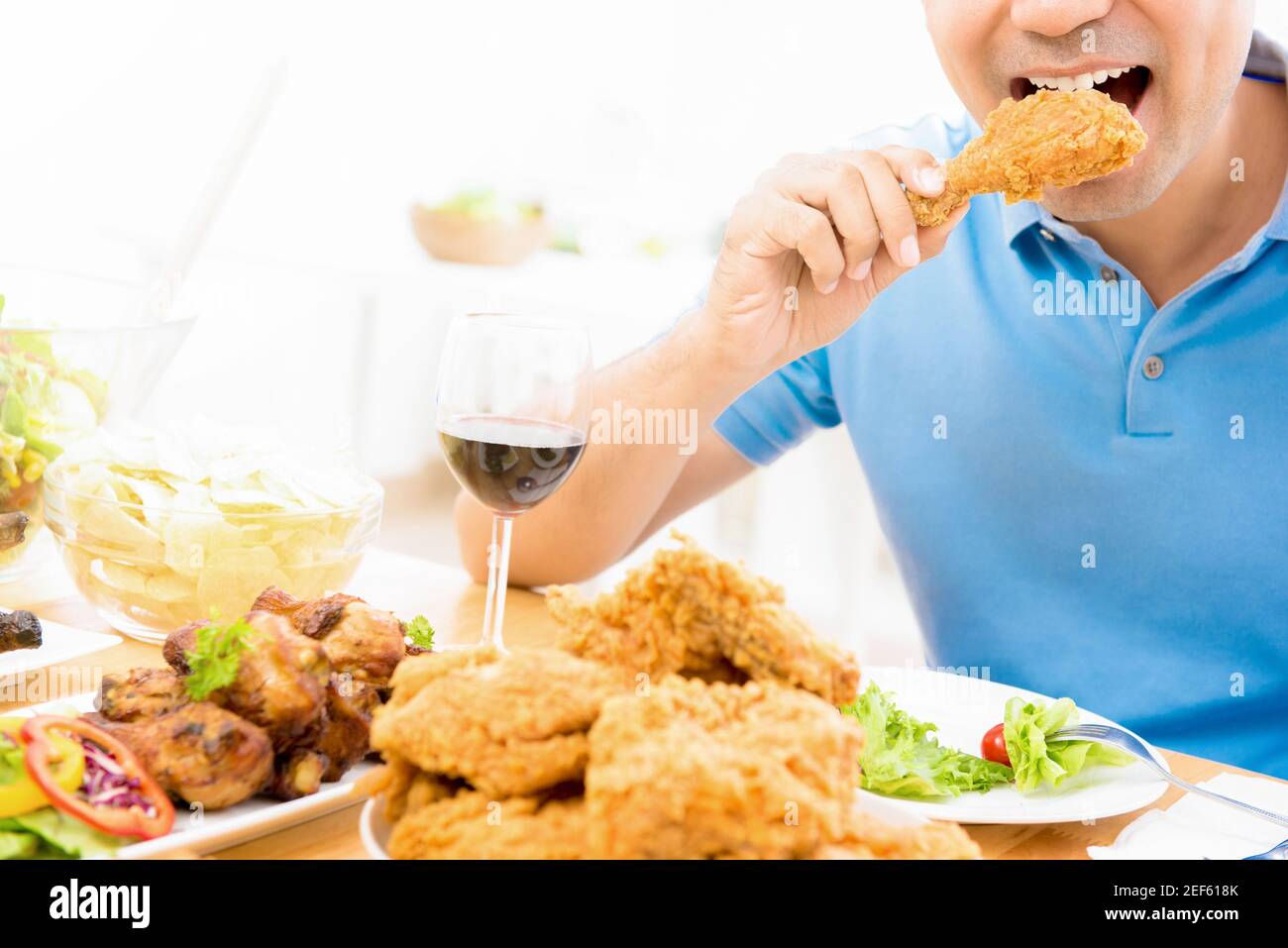 Young man eating fried chicken in the restaurant Stock Photo - Alamy