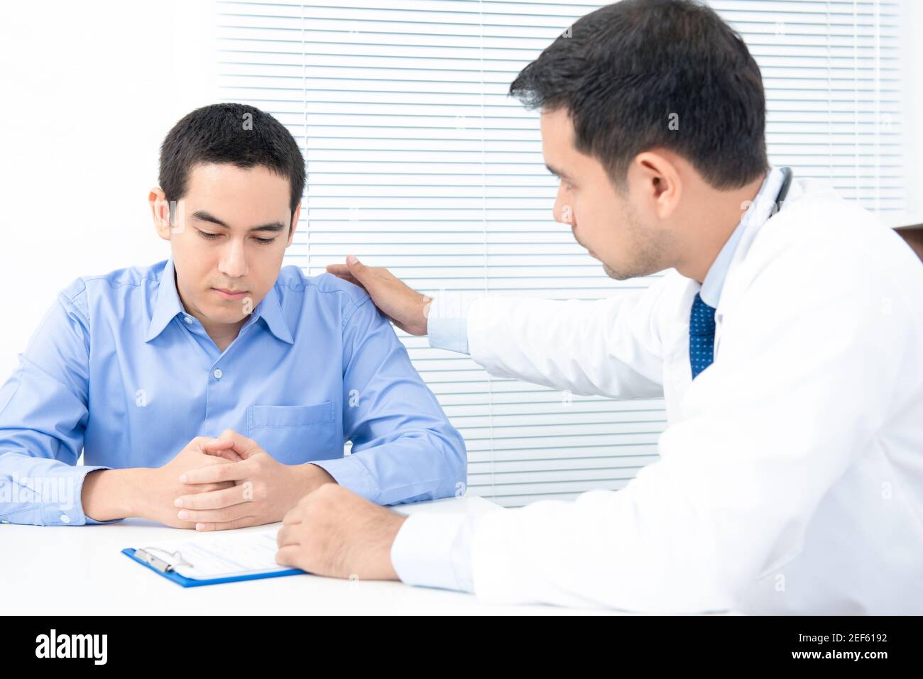 Doctor comforting depressed male patient Stock Photo - Alamy