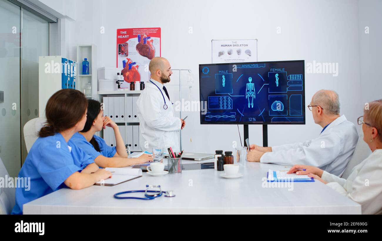 Man doctor presenting human internal structure in front of attantive ...