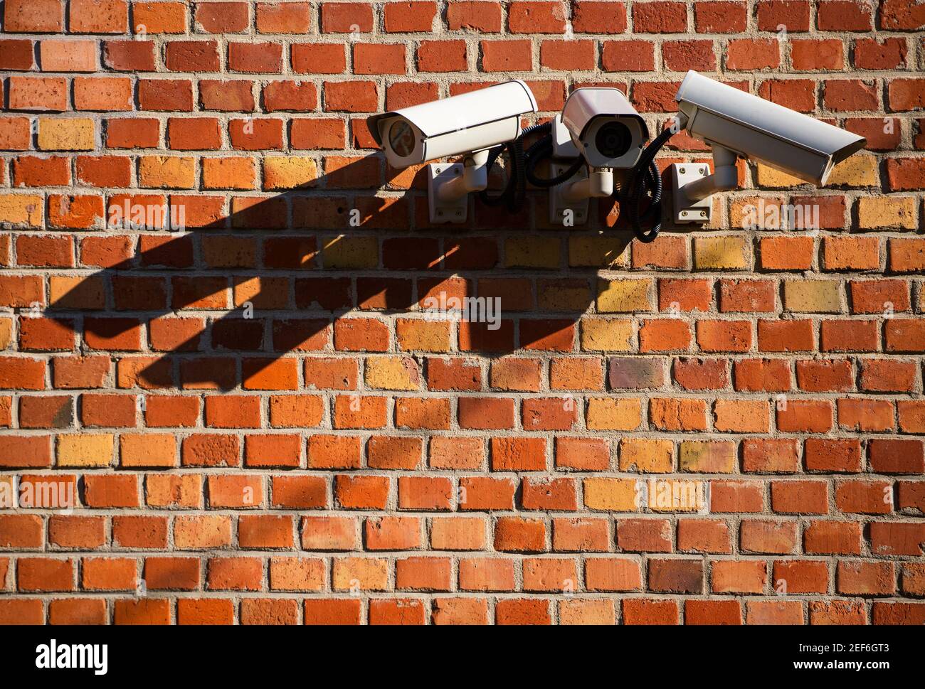 Group of security cameras on red brick wall Stock Photo - Alamy