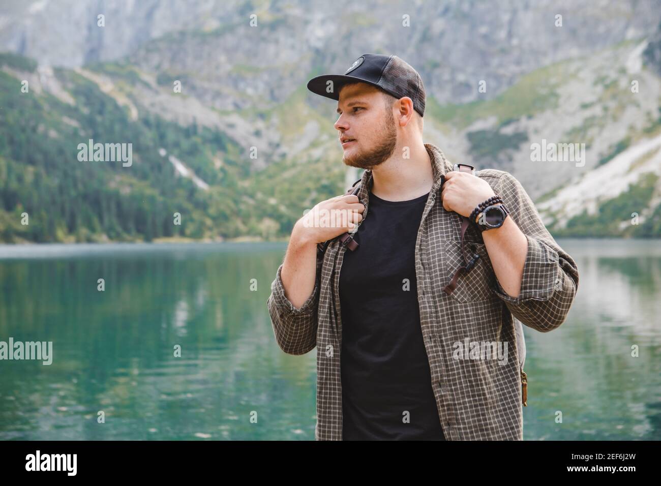 portrait of strong hiker man in front of lake in mountains travel ...