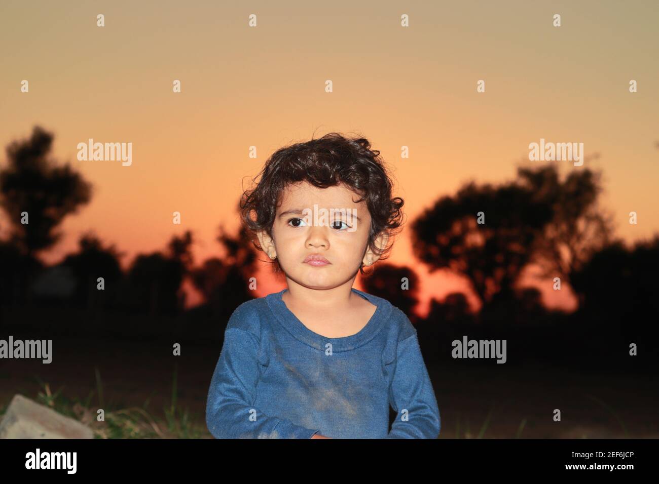 A portrait photo of a small Indian child playing in the garden after ...