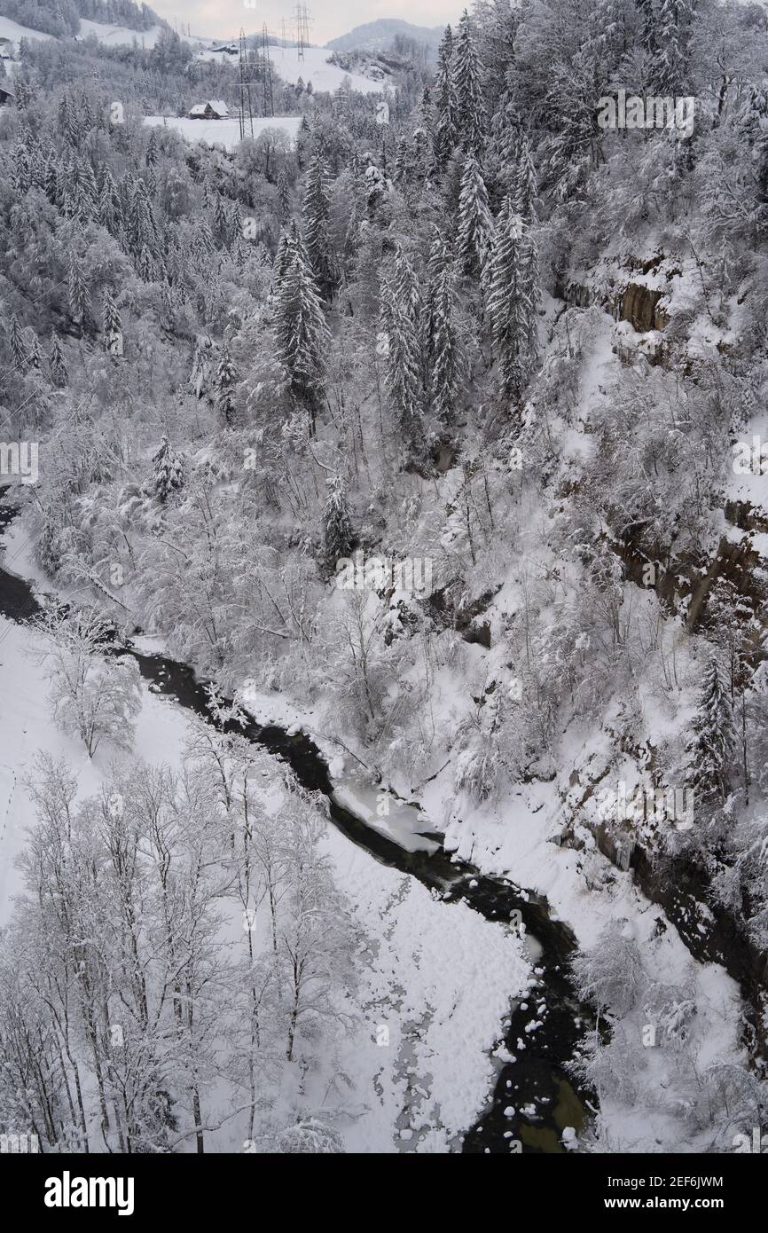 Snow covered landscape with a river and a forest after a heavy snowfall ...