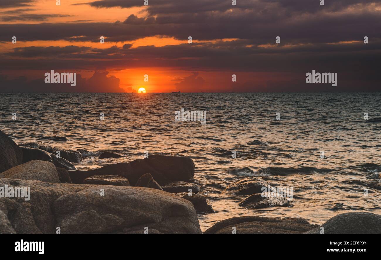 The stones in the sea with cloud sky in sunset time lighting and dark ...
