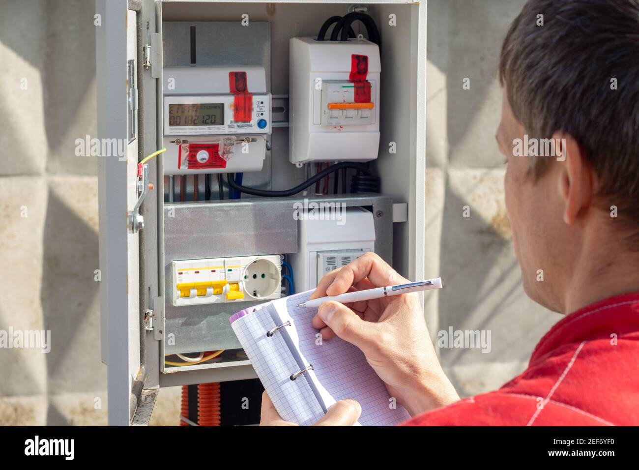 Man taking readings of an electric meter Stock Photo - Alamy