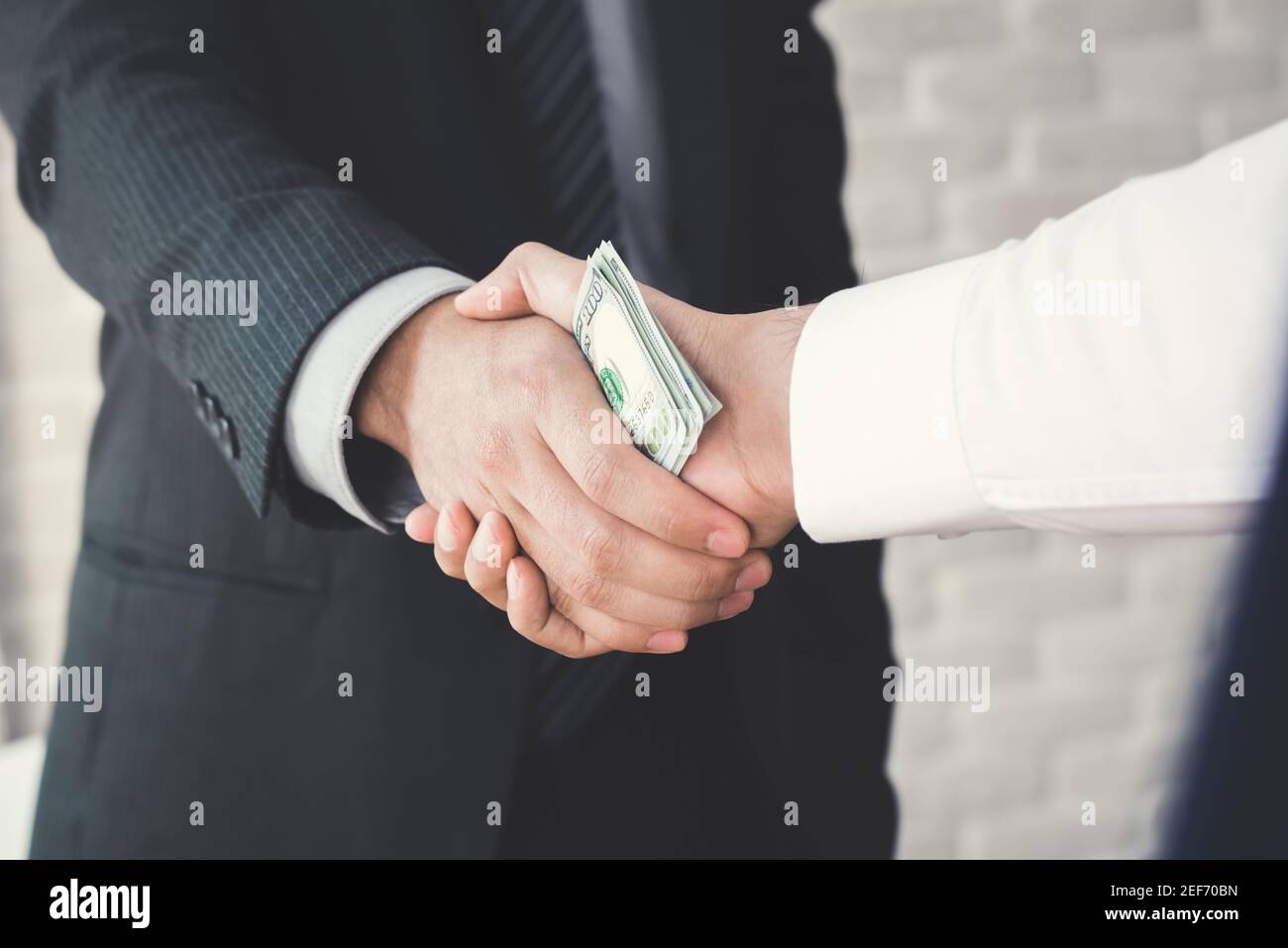 Businessmen making handshake with money in hands - bribery, corruption ...