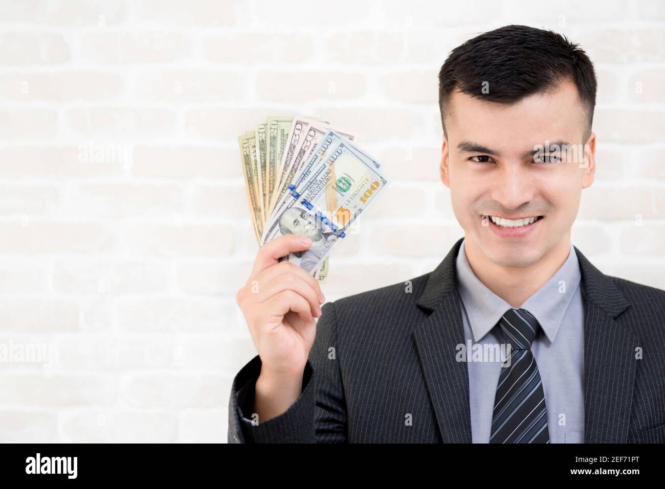 Young smiling businessman showing US dollar money Stock Photo - Alamy