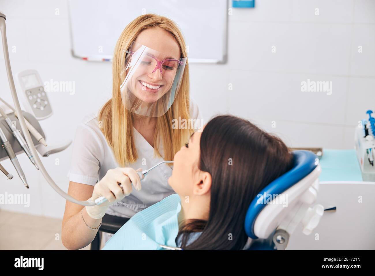 Positive delighted stomatologist treating her cute patient Stock Photo ...