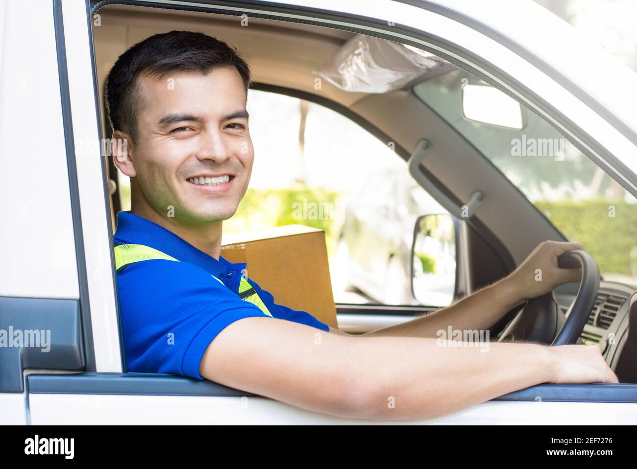 Delivery man driving a car with packages inside Stock Photo - Alamy