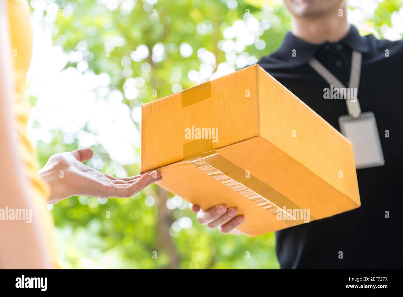 Delivery man delivering package to customer, close up at hand and box ...