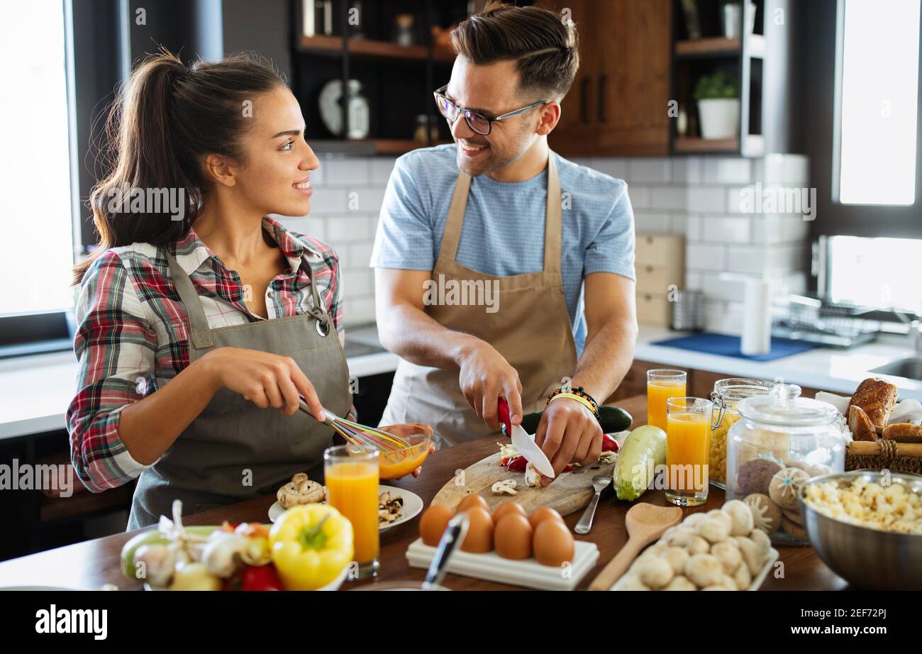 Beautiful young couple having fun in the kitchen while cooking Stock ...