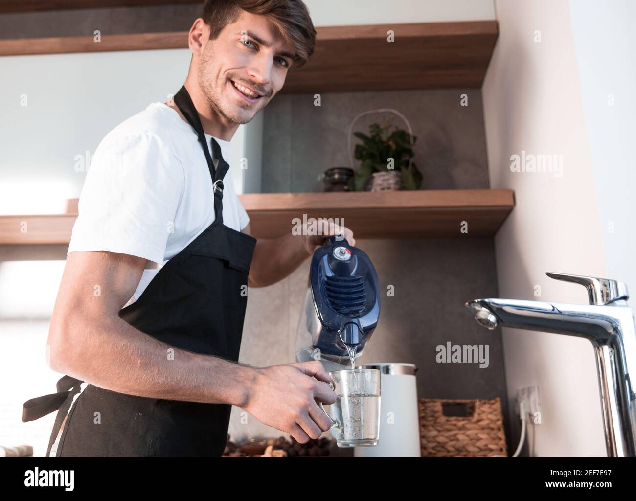 young man pouring clean water into a glass Stock Photo - Alamy