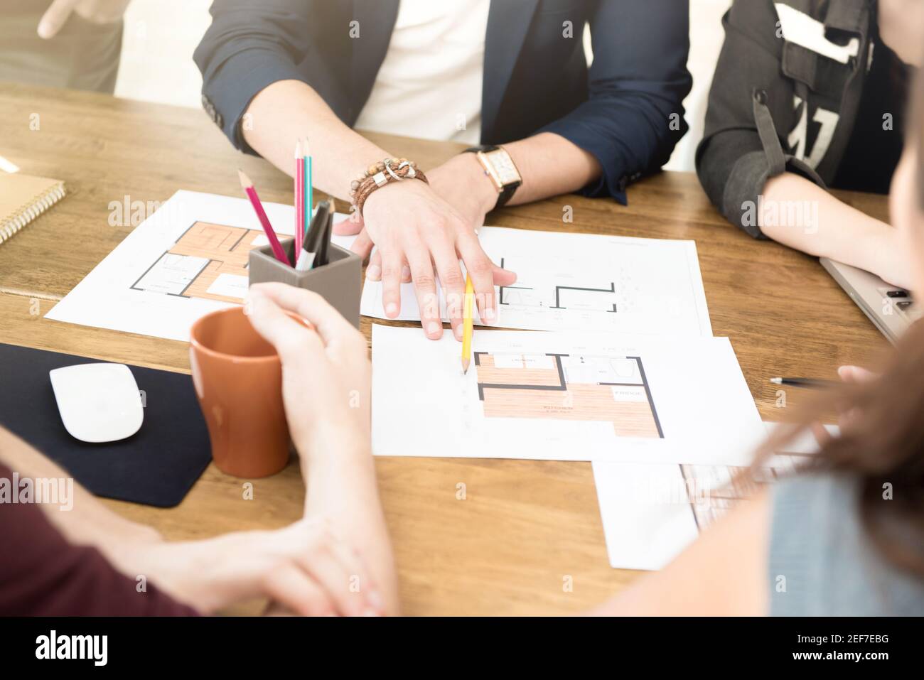 Group of architects (or interior designers) discussing floor plans in ...