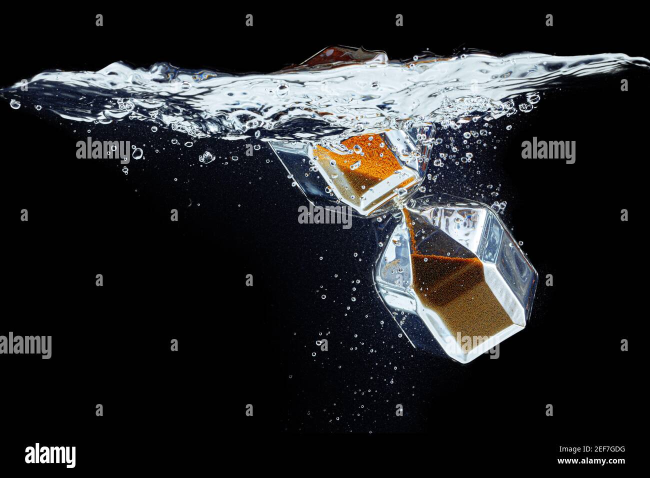 Hourglass diving into the water against black background Stock Photo ...