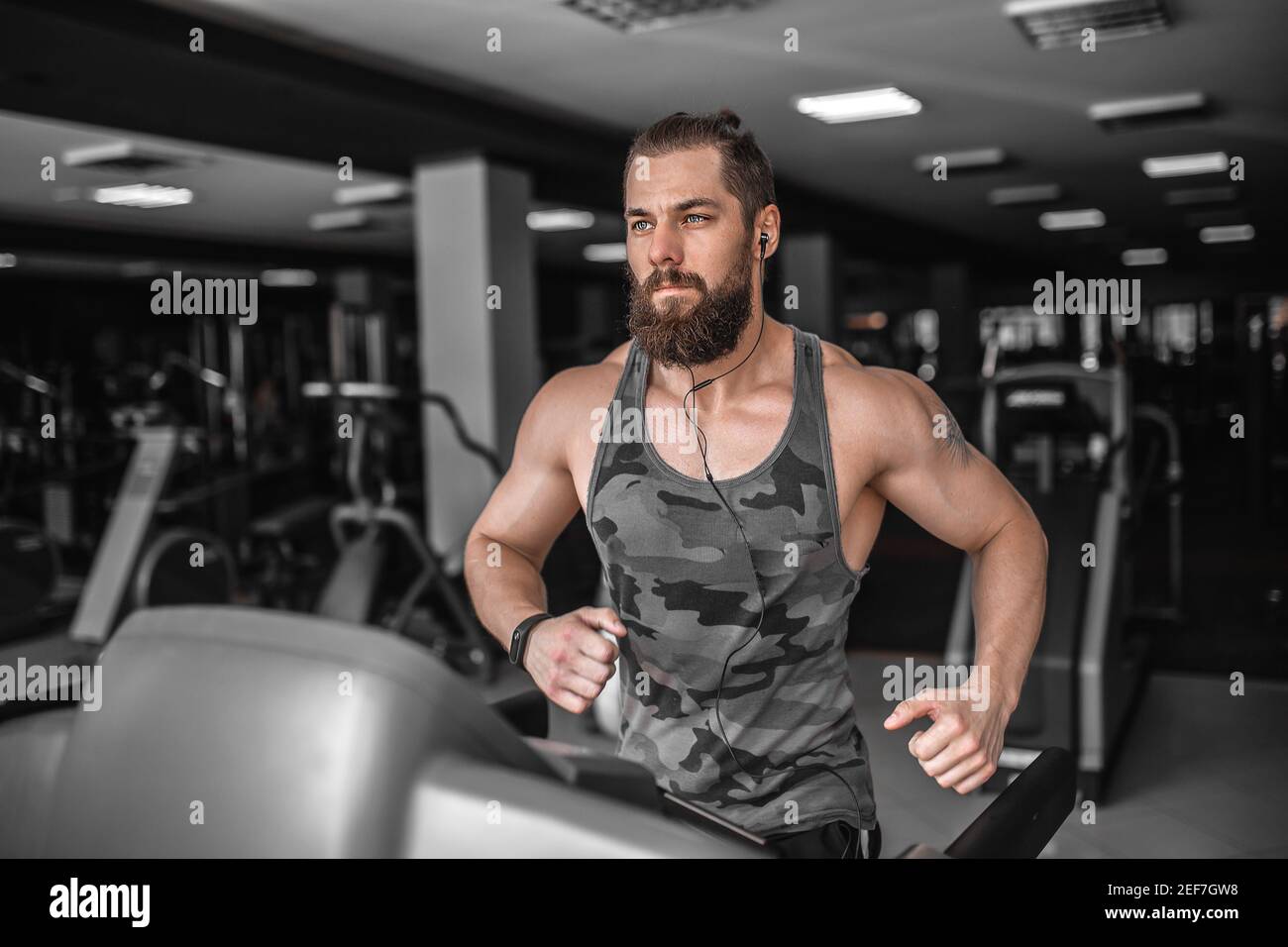 Adult strong bearded man running on treadmill in gym Stock Photo - Alamy