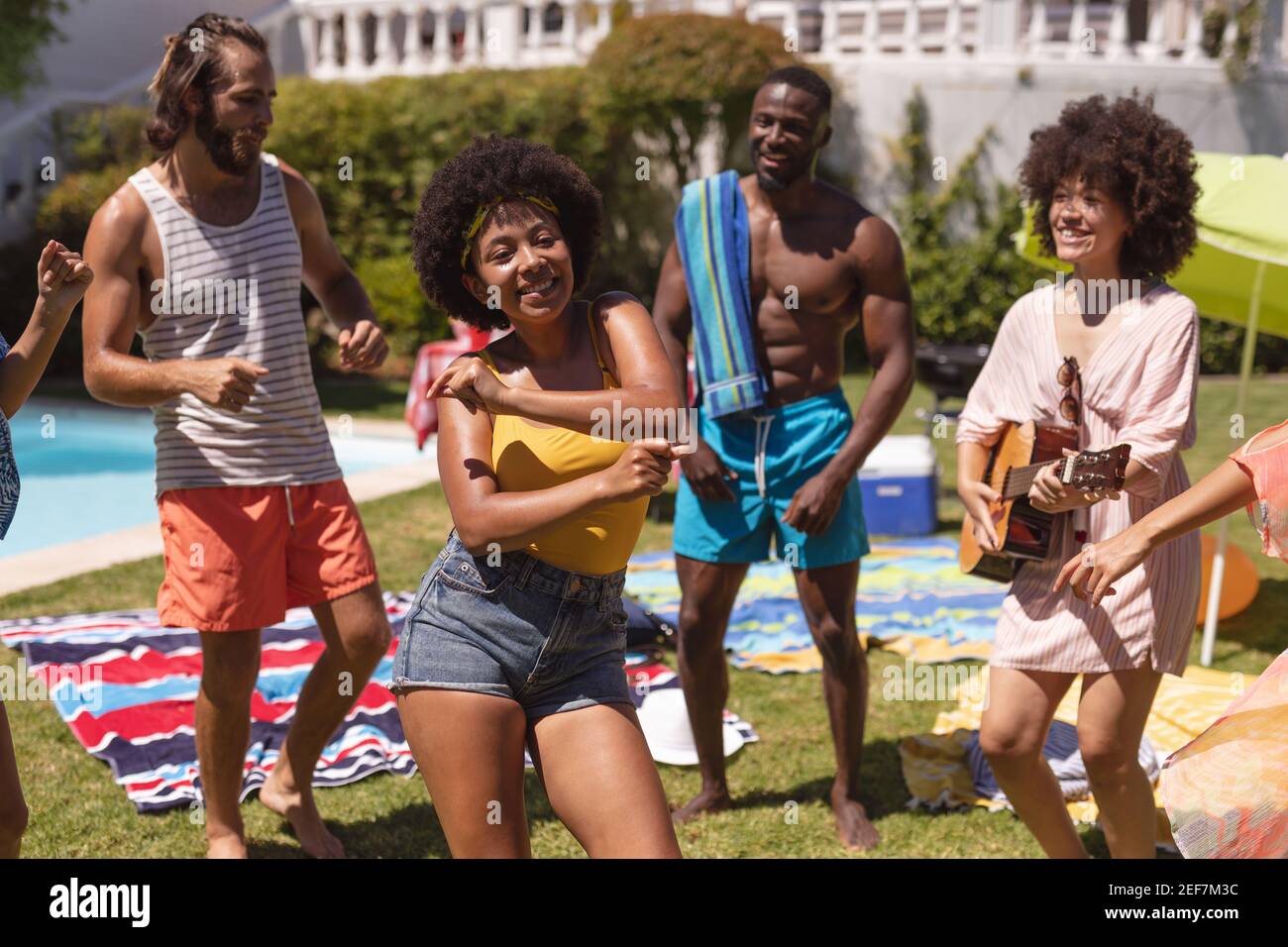 Diverse group of friends having fun and dancing at a pool party ...