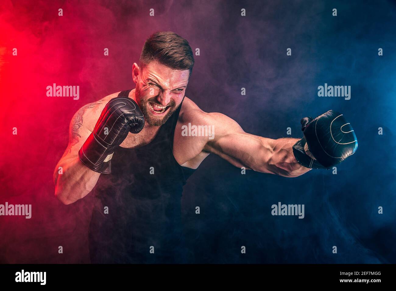 Bearded tattooed sportsman muay thai boxer in black undershirt and ...