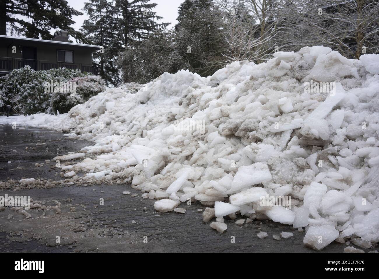 Dirty snow and ice piled up by the roadside in a neighborhood in the ...