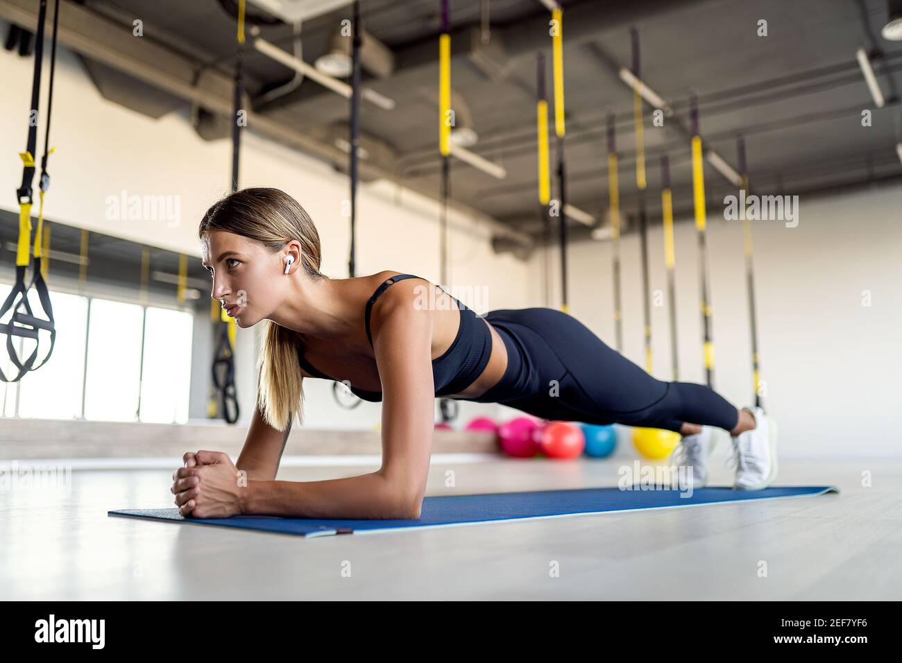 Full length of young beautiful woman in sportswear doing plank and ...
