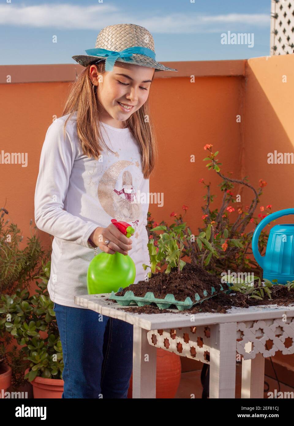 Image of a girl taking care of plants to grow them in the garden with a ...