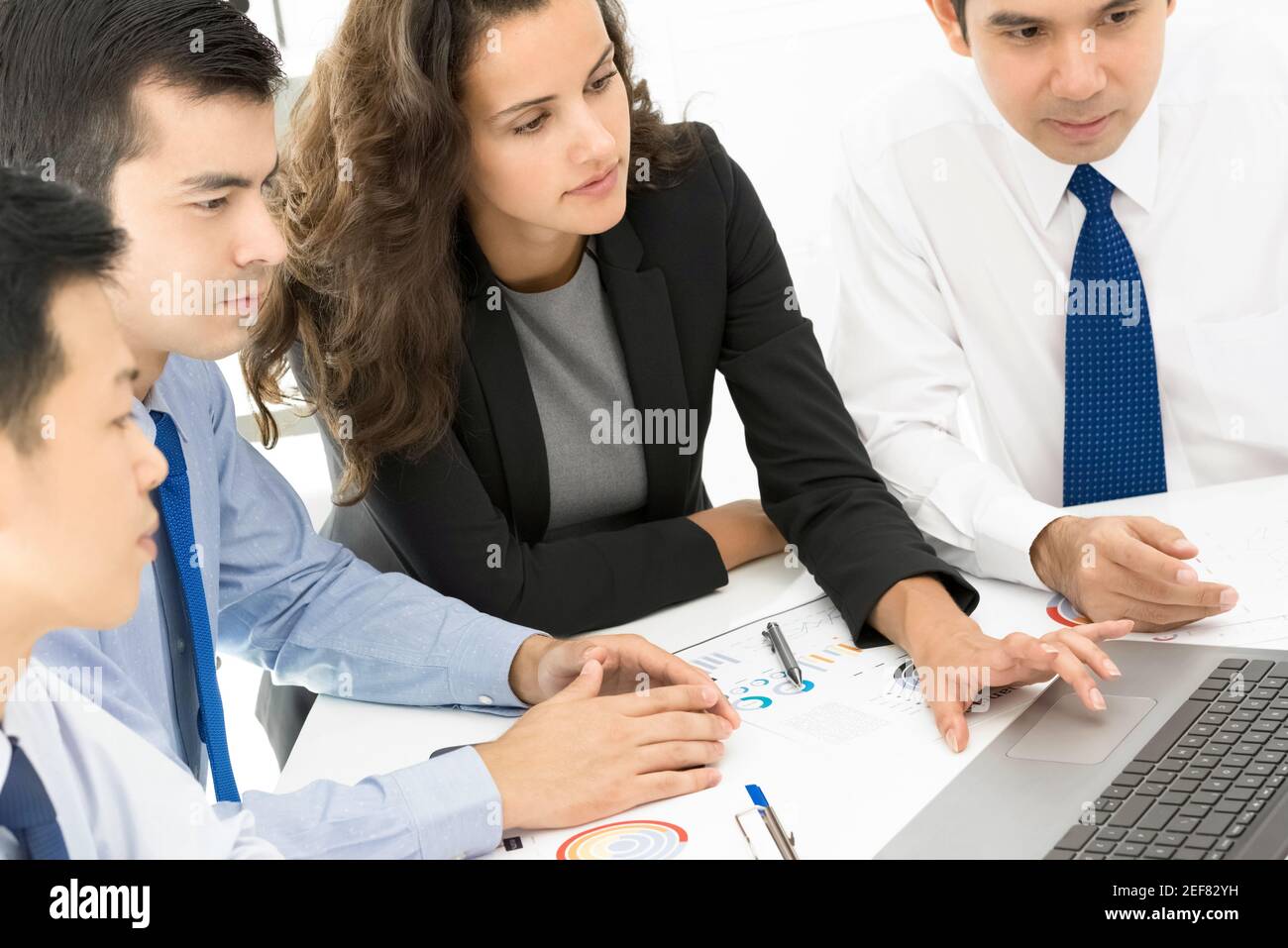 Group of business people looking at laptop computer screen, working ...