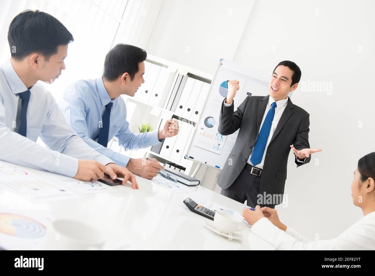 Powerful businessman as a meeting leader clenching his fist empowering ...