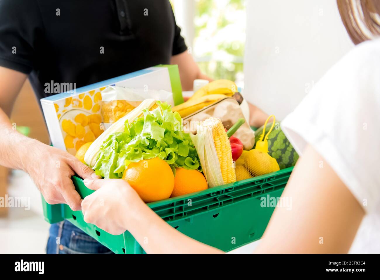 Delivery man delivering food to a woman at home - online grocery ...