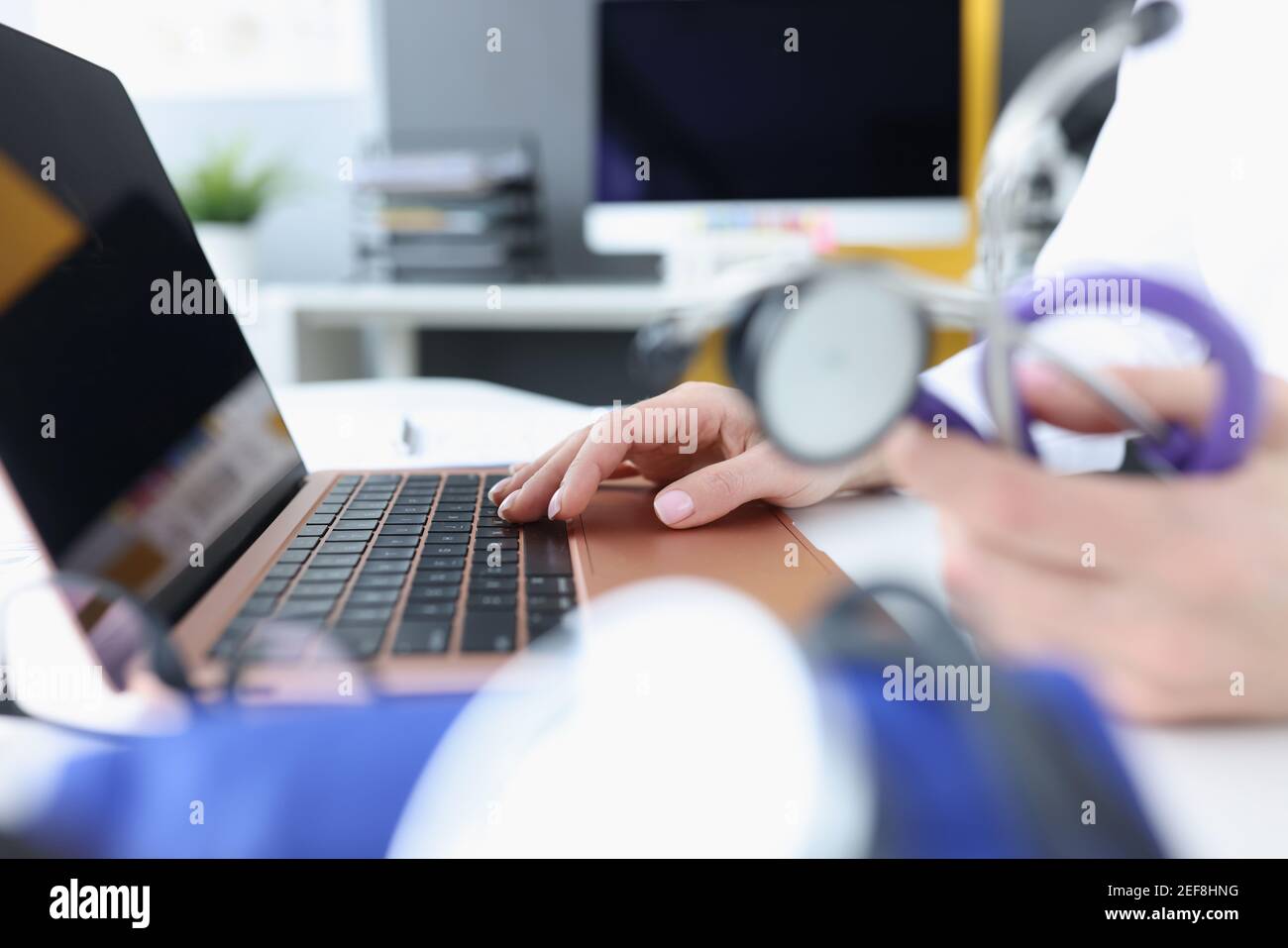 Doctor's hands holding stethoscope and working on laptop Stock Photo ...
