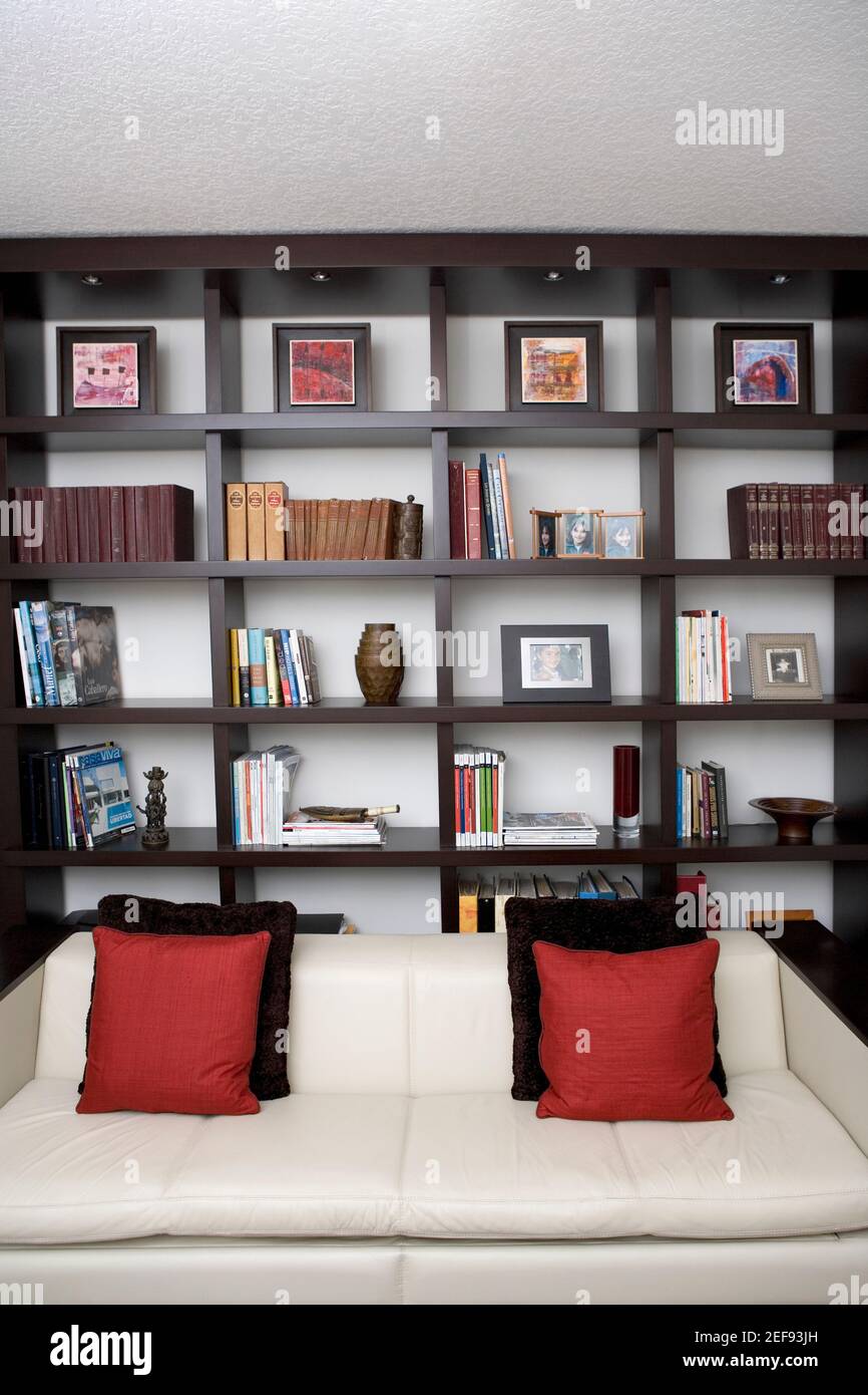 Couch in front of shelves in a living room Stock Photo - Alamy