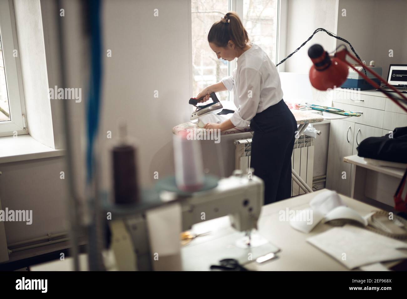 young girl seamstress while working on tailoring in her workshop Stock ...