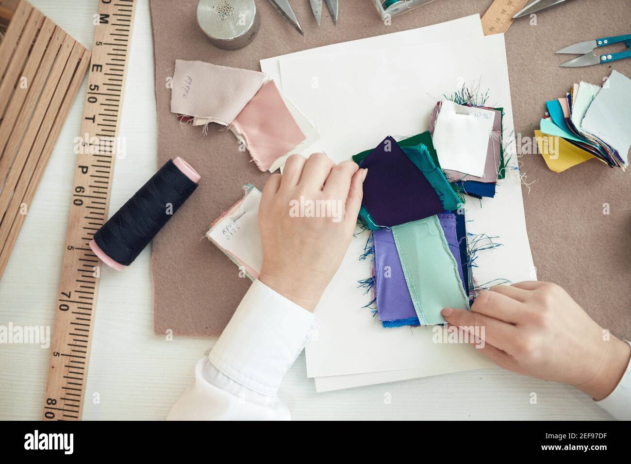 the seamstress chooses a sample of fabric for sewing clothes Stock ...