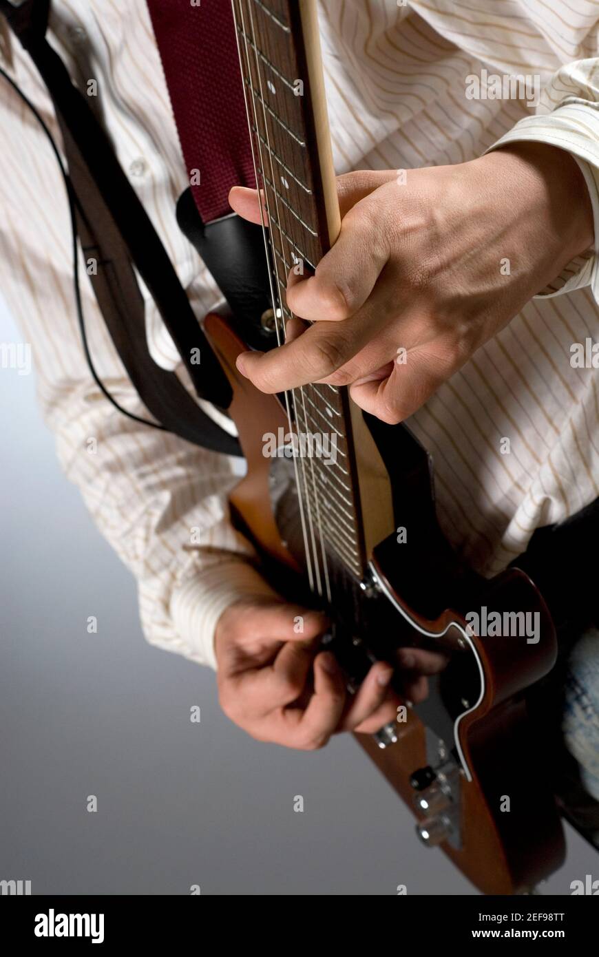 Mid section view of a male guitarist playing a guitar Stock Photo - Alamy