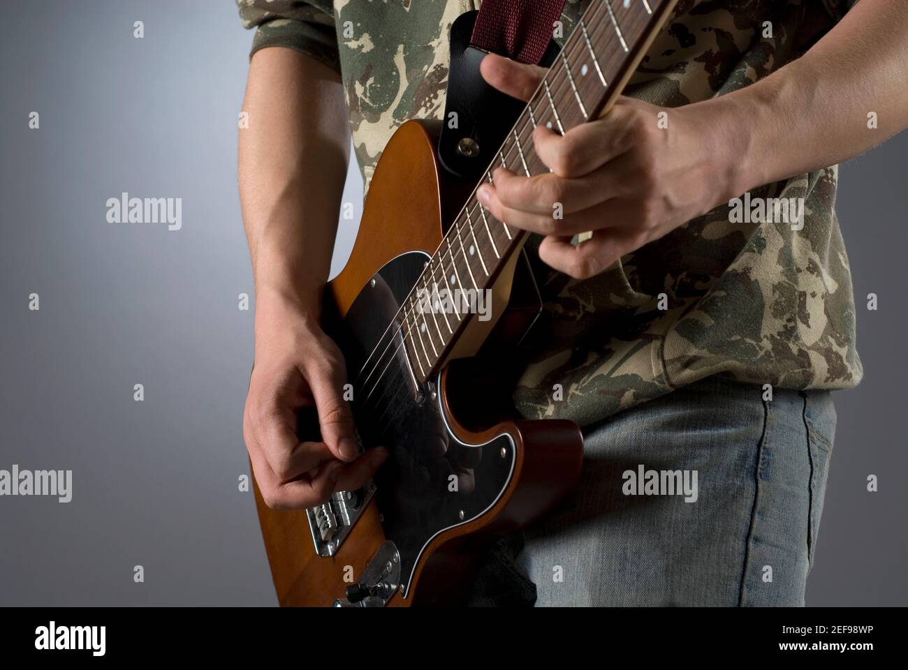 Mid section view of a male guitarist playing a guitar Stock Photo - Alamy