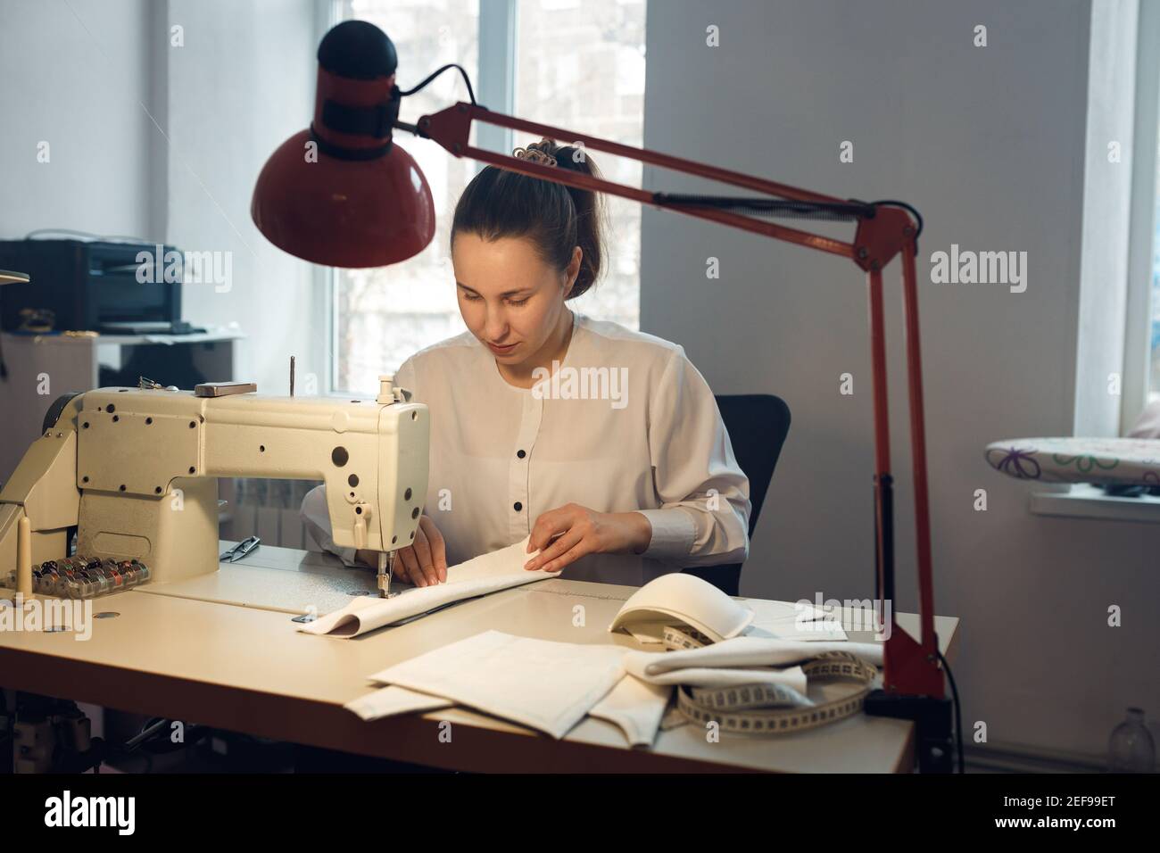 young girl seamstress while working on tailoring in her workshop Stock ...