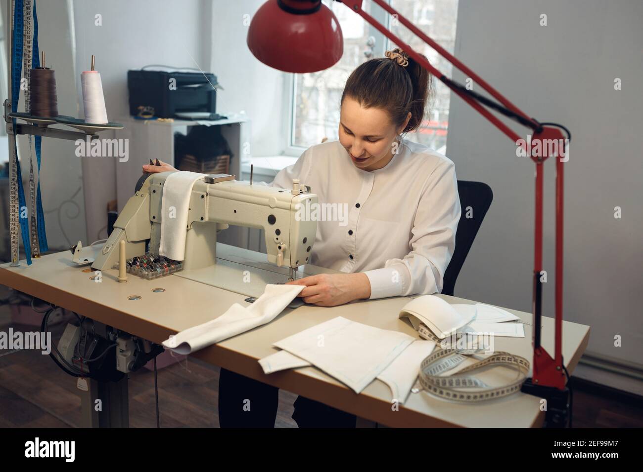 young girl seamstress while working on tailoring in her workshop Stock ...