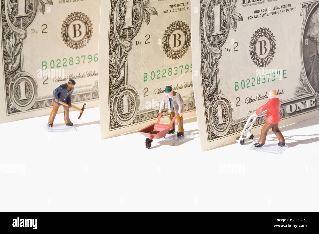 Figurines of manual workers with US dollar bills Stock Photo - Alamy