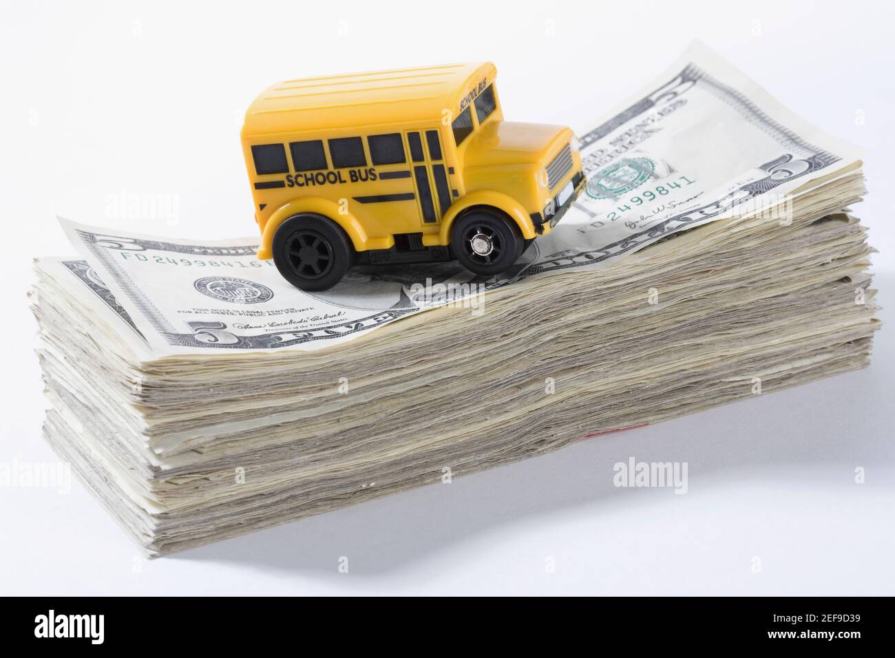 Close up of a toy school bus on a stack of US dollar bills Stock Photo ...