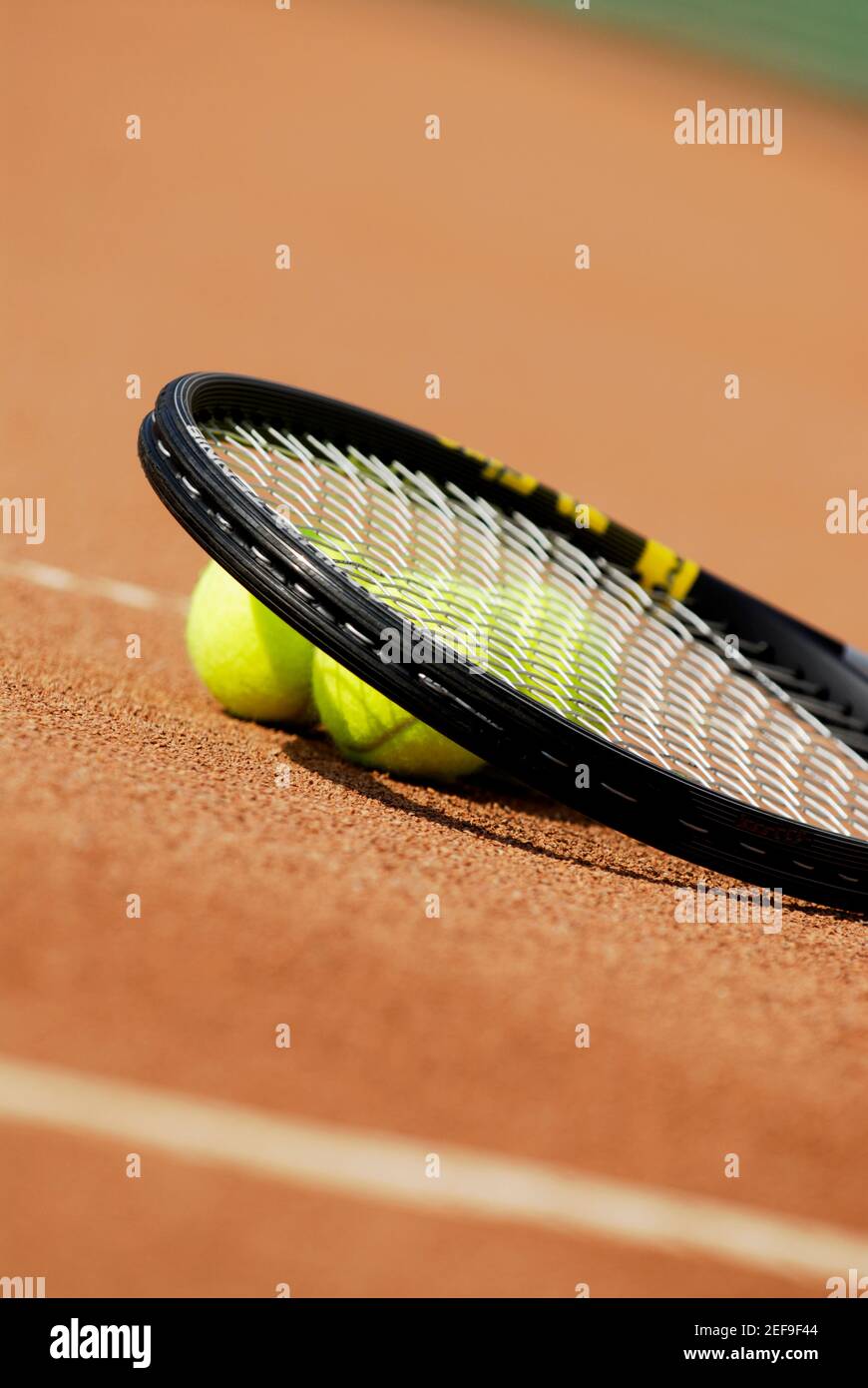 Three tennis balls under a tennis racket Stock Photo - Alamy