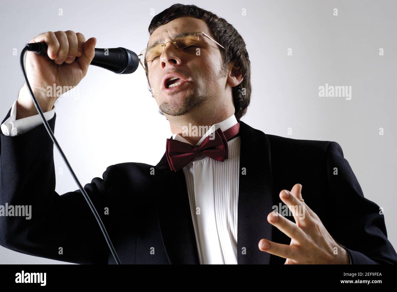 Close-up of a young man singing into a microphone Stock Photo - Alamy