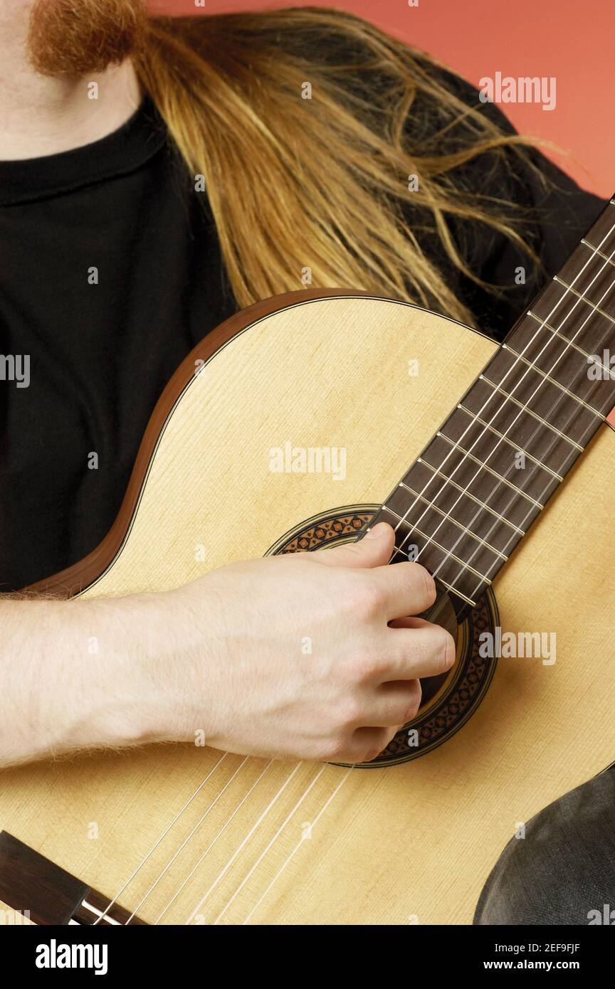 Mid section view of a musician playing an acoustic guitar Stock Photo ...